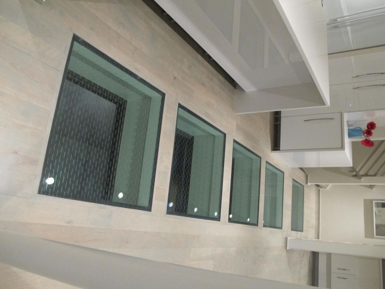 How to use glass floor panels to connect spaces in a custom home